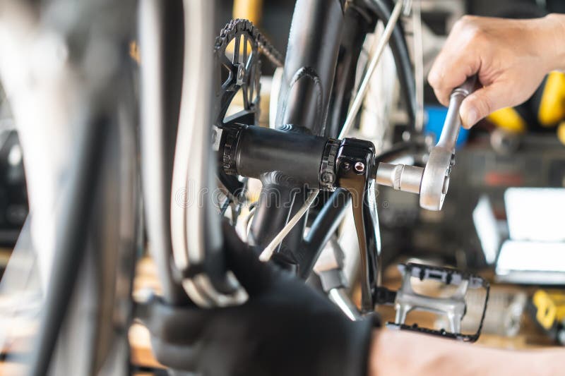 Technician Makes Adjustments To Crankset on a Folding Bicycle Working ...