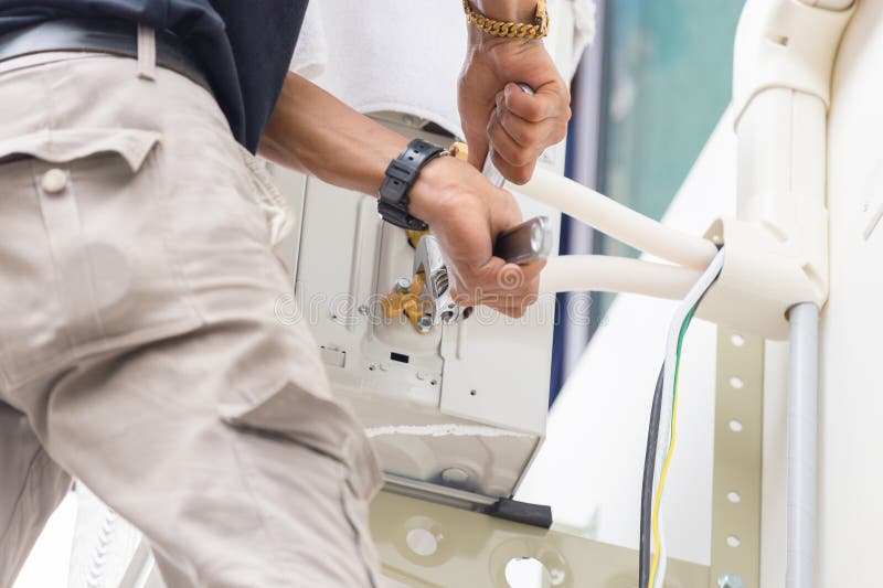 Technician Man Using a Wrench Fixing Modern Air Conditioning System ...