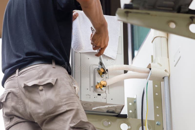 Technician Man Using a Wrench Fixing Modern Air Conditioning System ...