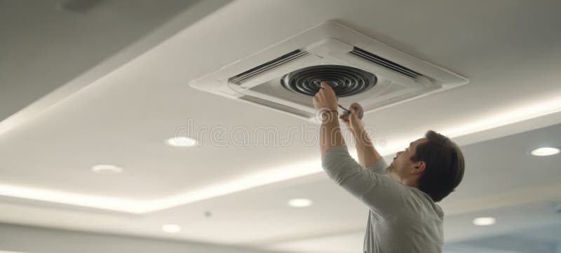 The Technician Performing Maintenance on a Ceiling Air-conditioning ...