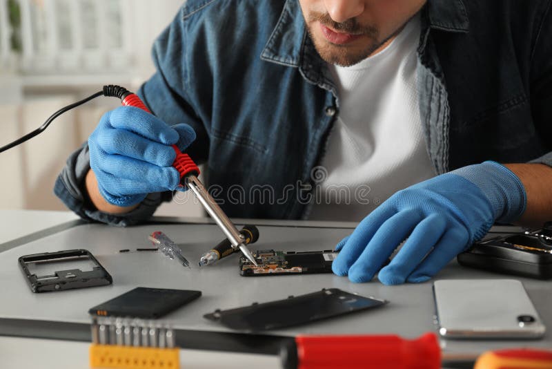 Technician Repairing Broken Smartphone at Table Stock Photo - Image of ...