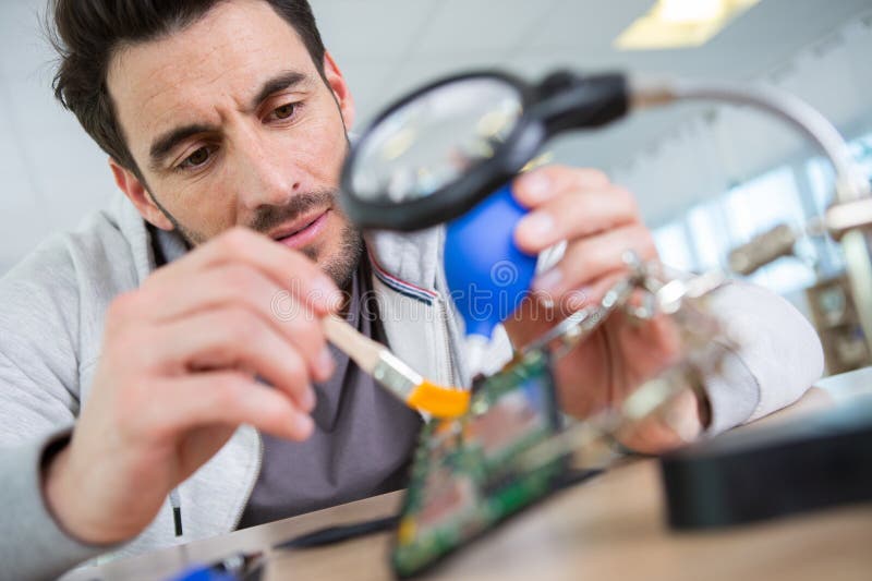 Technician Repairing Electronics Components through Magnifying Glass ...