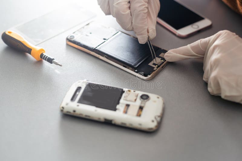 Technician Repairing Inside of Mobile Phone by Soldering Iron. the ... Technician Repairing Inside of Mobile Phone by Soldering Iron. the ...