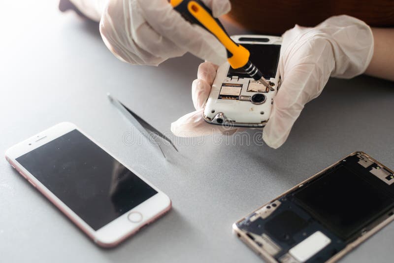 Technician Repairing Inside of Mobile Phone by Soldering Iron. the ... Technician Repairing Inside of Mobile Phone by Soldering Iron. the ...