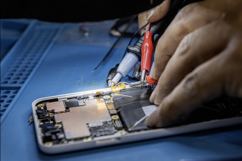 A Technician Repairing a Mobile Phone on His Blue Antielectromagnetic ...