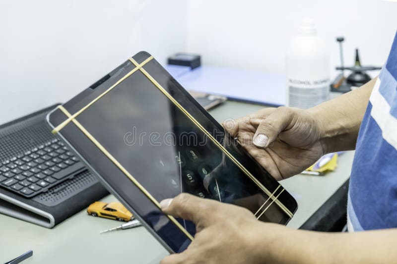 A Technician Repairing the Screen of a Large, Thin Tablet in His ...
