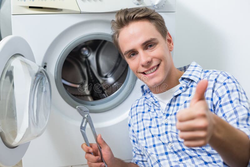 Technician Repairing Washing Machine while Gesturing Thumbs Up Stock ...