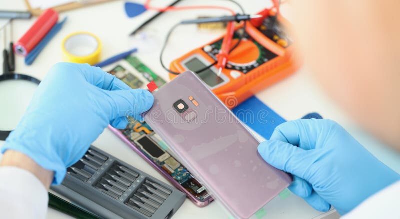Technician Repairs Broken Smartphone at Table in Workshop Stock Image ...
