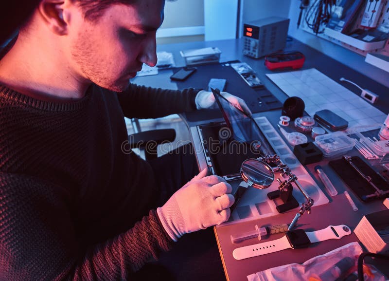 The Technician Repairs a Broken Tablet Computer in a Repair Shop ...