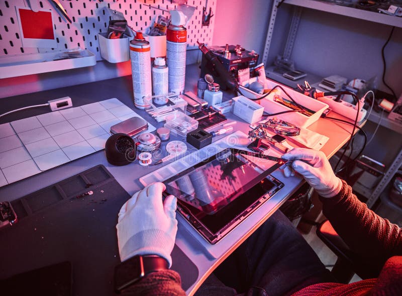 The Technician Repairs a Broken Tablet Computer in a Repair Shop ...
