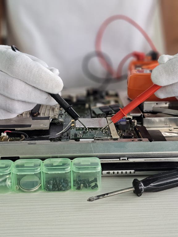 Technician Repairs Computer Motherboard with Multimeter and Tools Stock ...