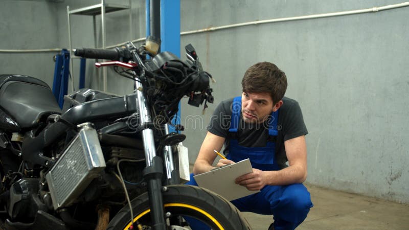 Technician Repairs a Motorcycle and Takes Notes Stock Image - Image of ...