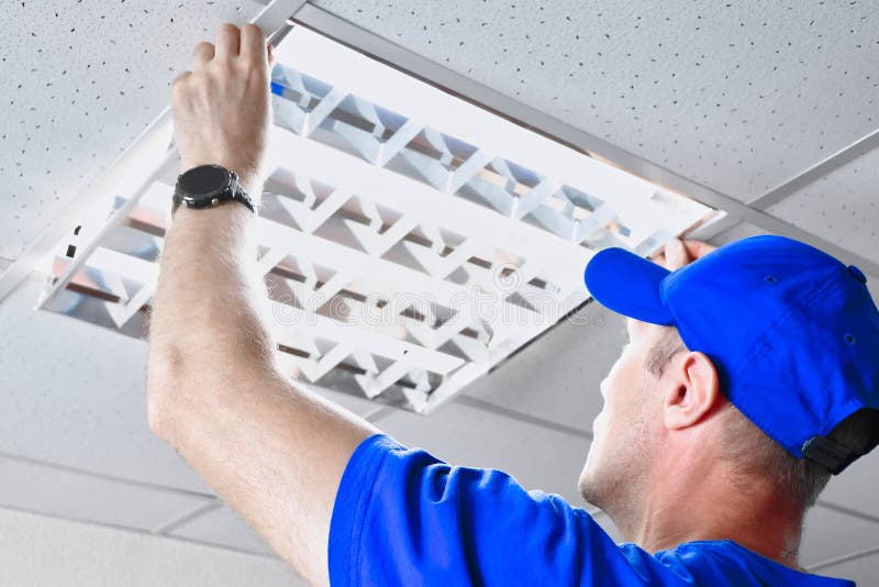 Technician Securing and Adjusting Fluorescent Light Panel in Commercial Office Ceiling. Stock ...