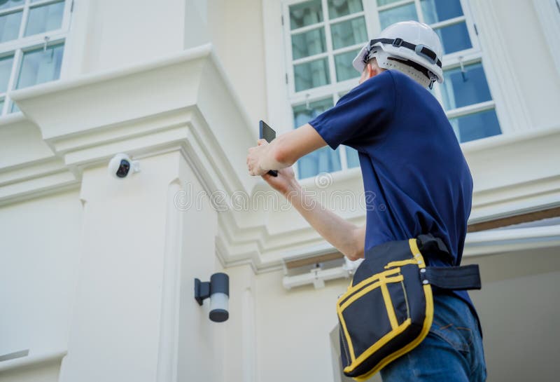 A Technician Sets Up a CCTV Camera on the Facade of a Residential ...