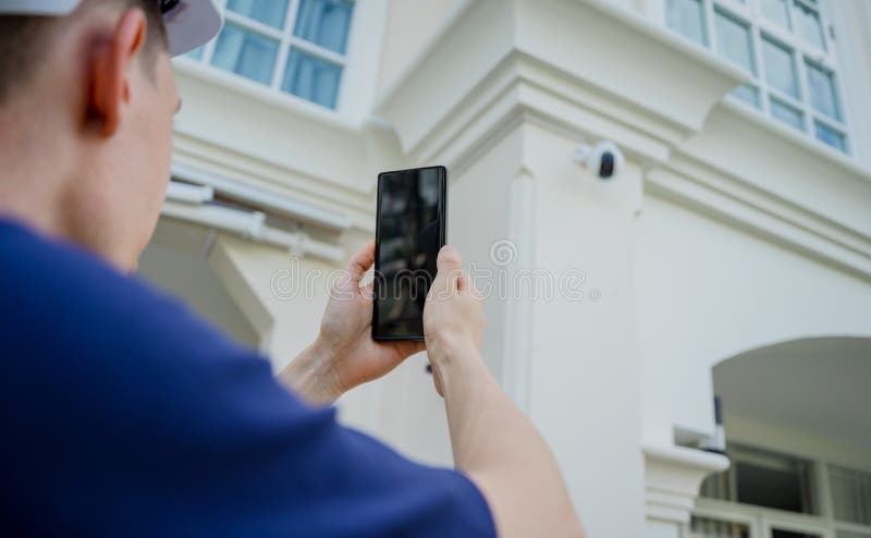 A Technician Sets Up a CCTV Camera on the Facade of a Residential ...