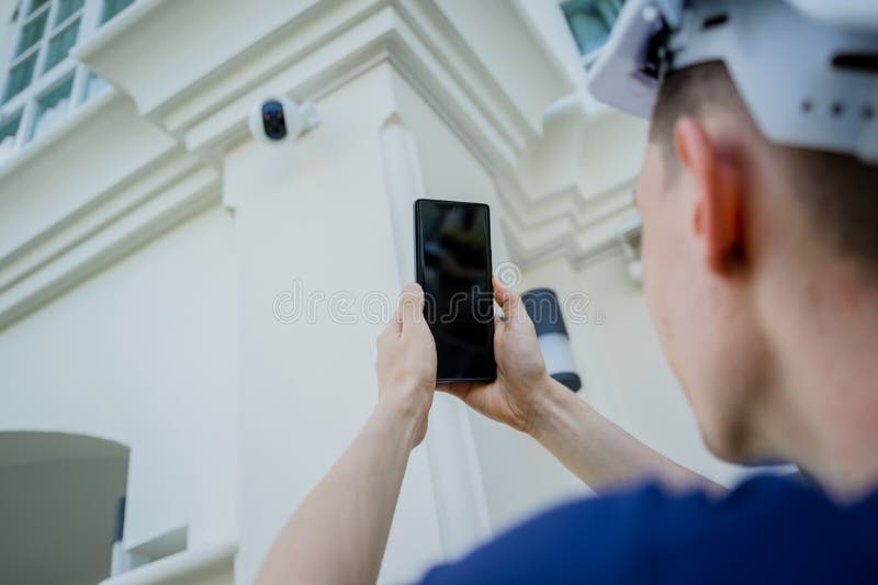 A Technician Sets Up a CCTV Camera on the Facade of a Residential ...