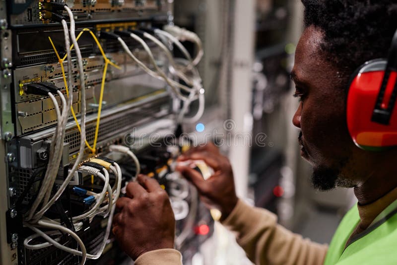 Technician Setting Up Network in Server Room and Wearing Ear Protection ...