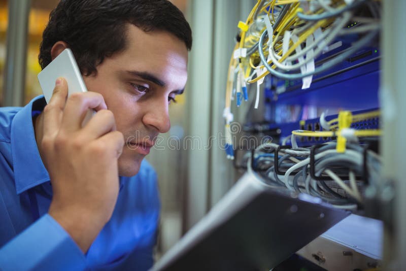 Technician Talking on Mobile Phone while Analyzing Server Stock Photo ...