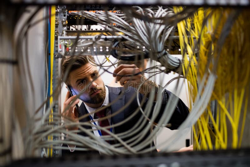 Technician Talking on Mobile Phone while Checking Cables Stock Photo ...