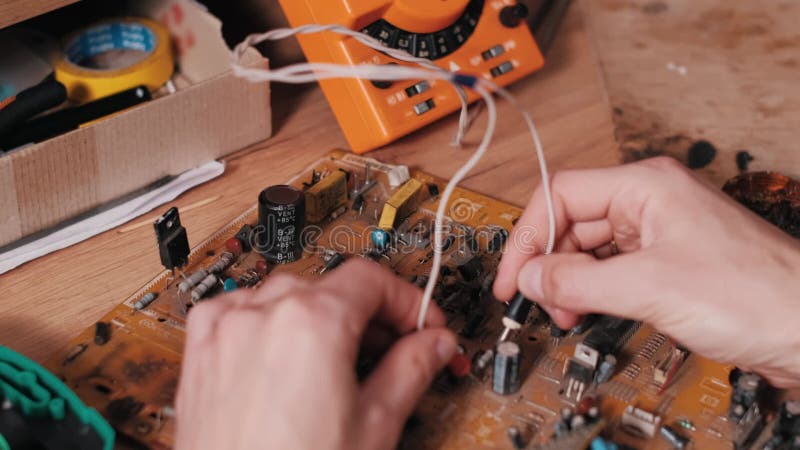 Technician Testing Circuit Board Components with Multimeter Probes ...