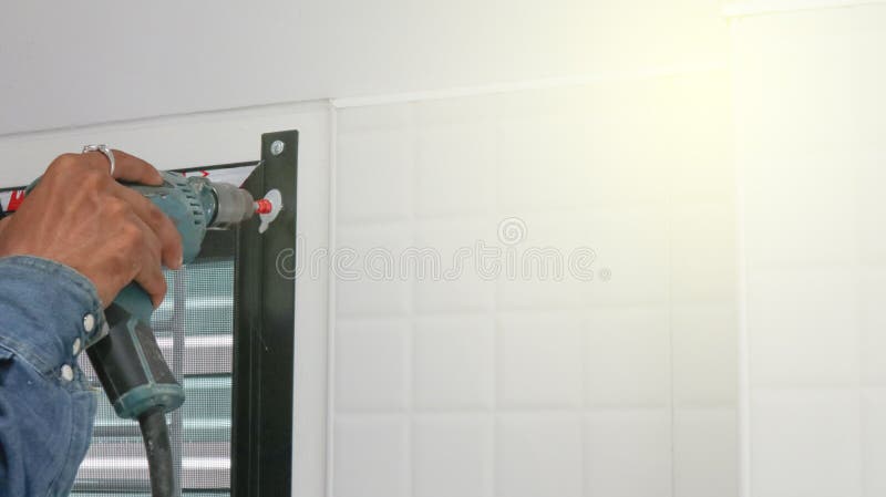 Technician Uses an Electrical Drilling Machine by Hand To Work at a ...