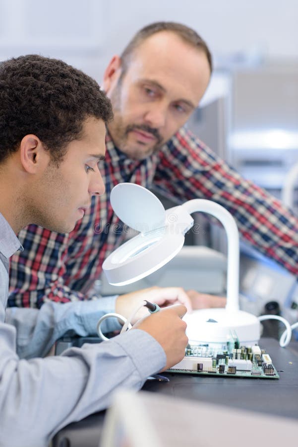Technician Using Magnifying Glass for Analyzing Computer Mainboard ...