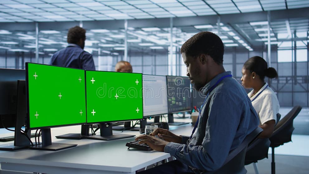 Technician Using Multi Monitor Green Screen Computer Setup in Server ...