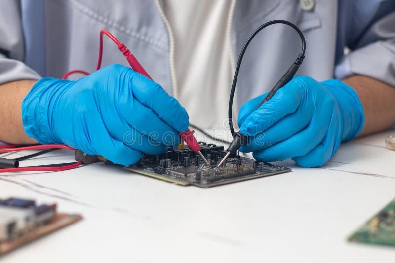 Technician Using Tool To Measure Circuit Board, Check and Repair Stock ...