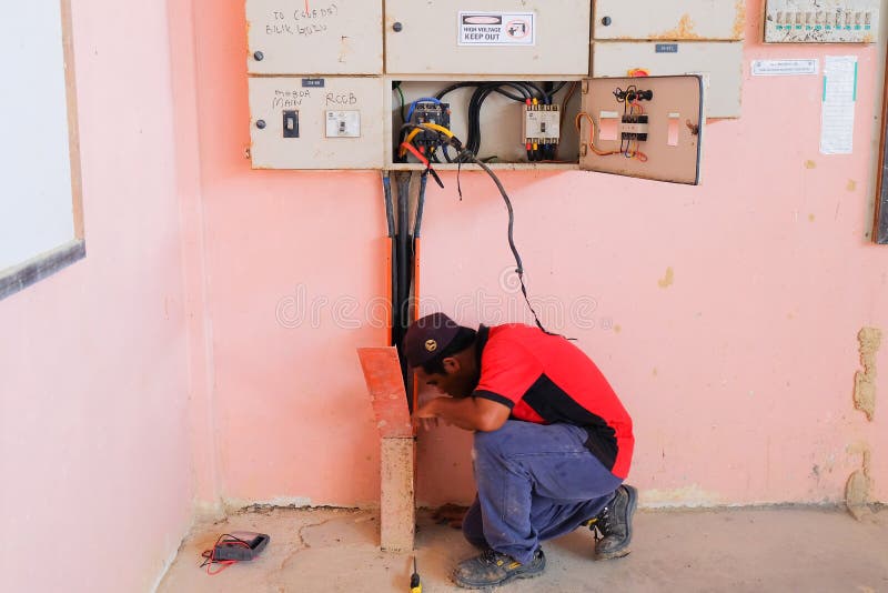 Technician Wiring Cable in Front of Electrical Panel for Control and ...