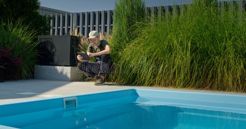 Technician Working by the Pool, Checking a Tablet while Surrounded by ...