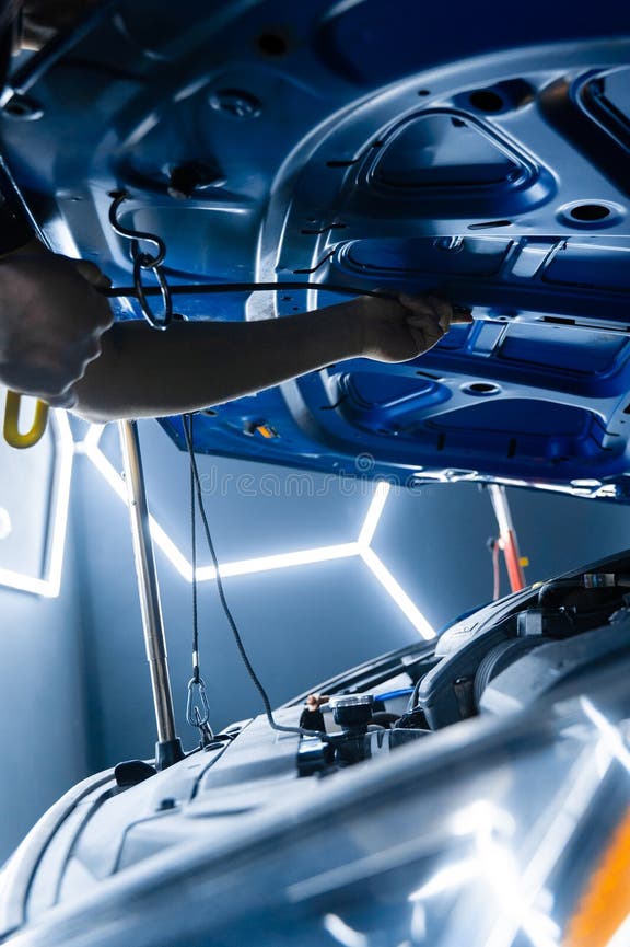 Technician Working Under Hood Performs Precision PDR Paintless Dent ...