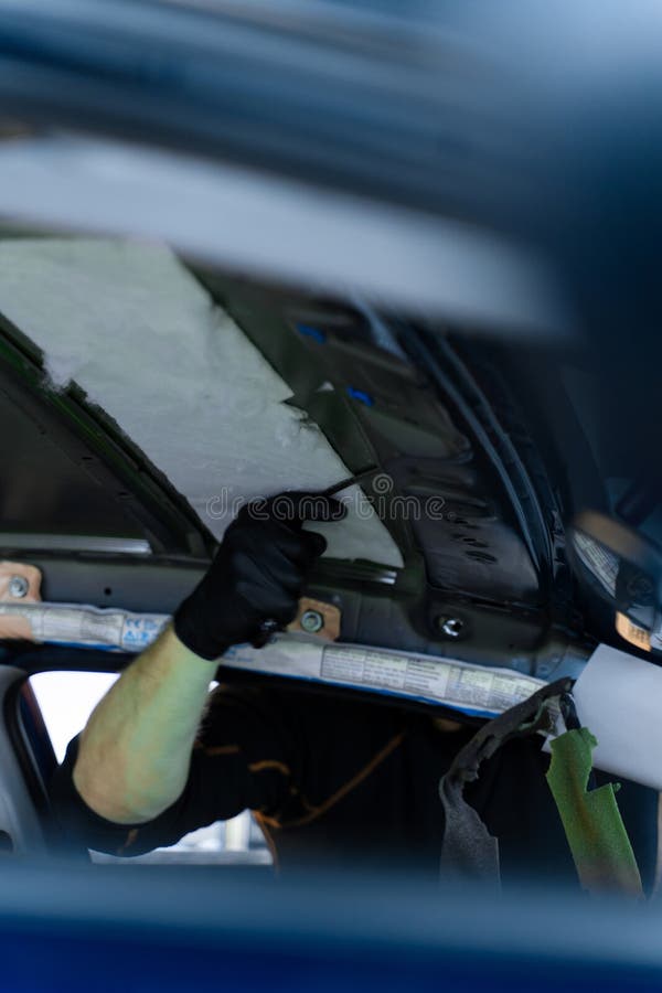 Technician Working Under the Roof Liner Performs Structural Repairs ...