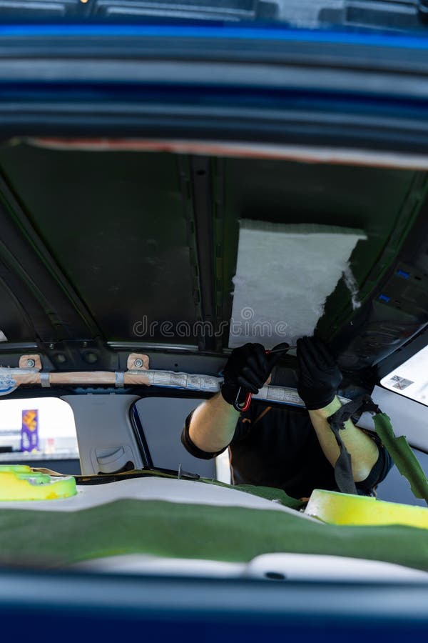 Technician Working Under the Roof Liner Performs Structural Repairs ...
