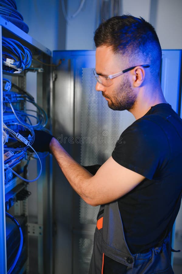 A Technician Works with Server Equipment in a Data Center. a Man ...