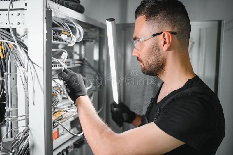 A Technician Works with Server Equipment in a Data Center. a Man ...