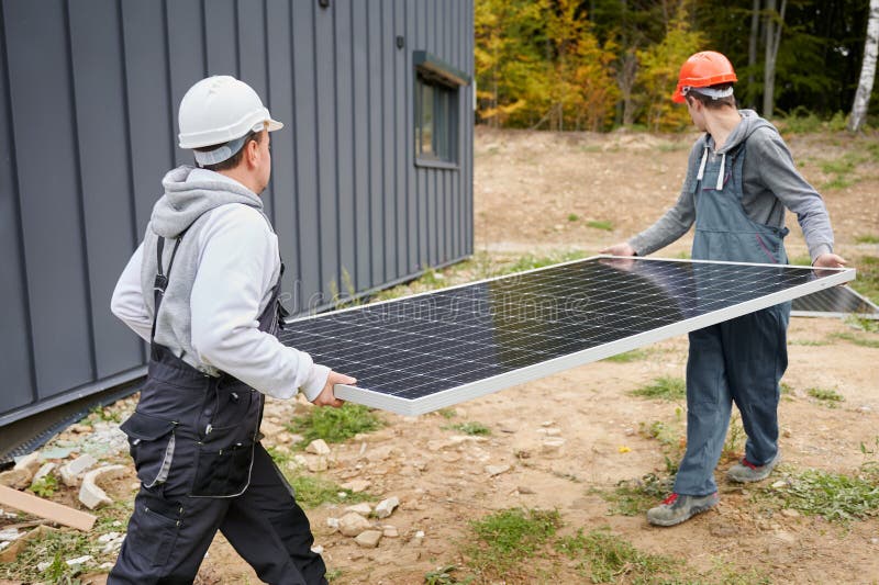 Technicians Carrying Photovoltaic Solar Module while Installing Solar ...