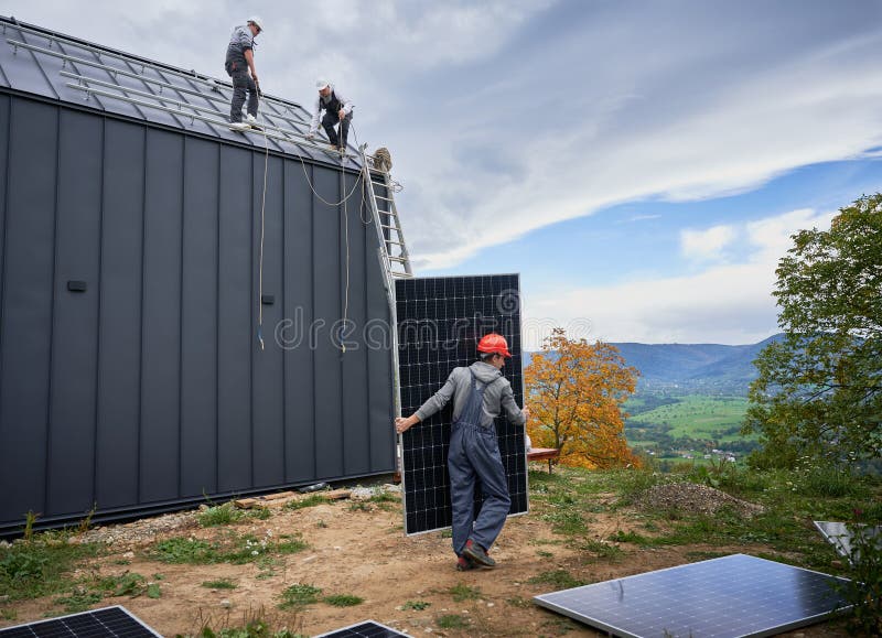 Technicians Carrying Photovoltaic Solar Module while Installing Solar ...