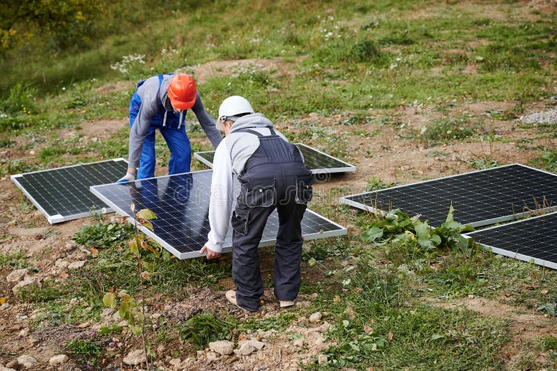 Technicians Carrying Photovoltaic Solar Module while Installing Solar ...