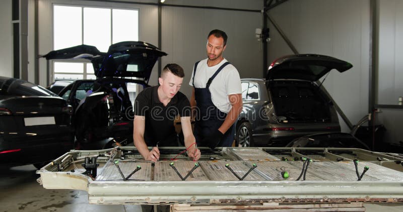Technicians Repairing Electric Car Battery in Workshop Stock Video ...