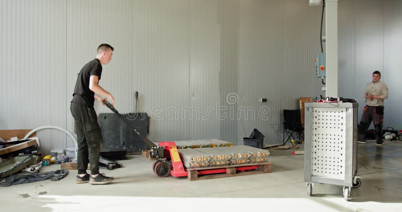 Technicians Working on Electric Car Battery Cell Module in Workshop ...
