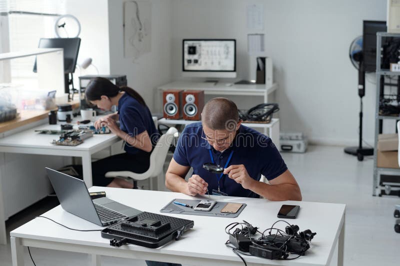 Technicians Working in Electronics Repair Workshop Stock Photo - Image ...