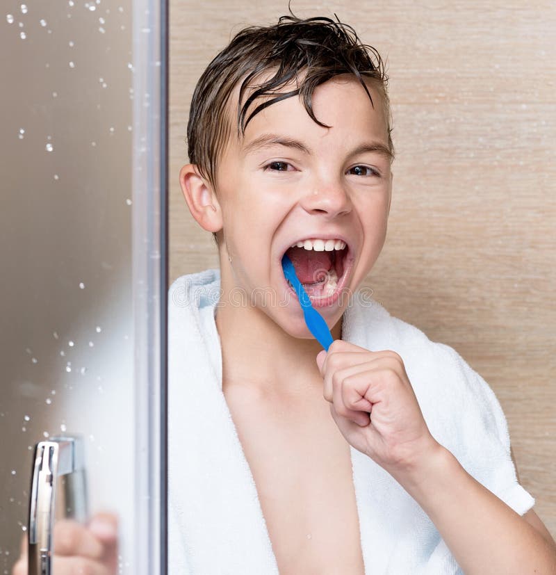 Teen boy brushing teeth stock photo. Image of handsome - 73147378