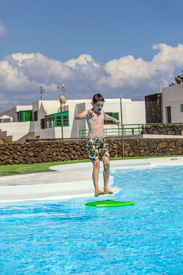 Teen Boy Jumps into the Pool with His Boogie Board Stock Photo - Image ...