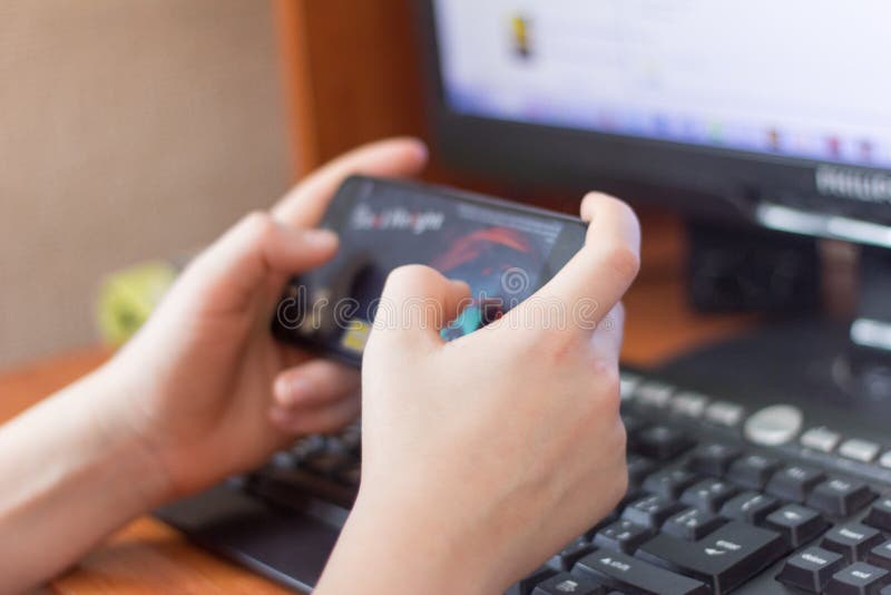 Teen Boy Playing on Computer and Phone at the Same Time Stock Photo ...