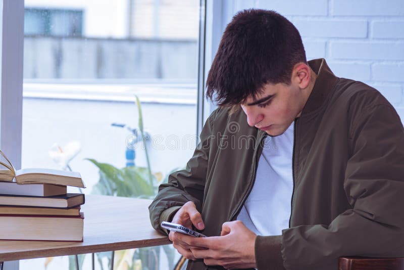 Boy Student with Mobile Phone at Desk Stock Image - Image of teen ...