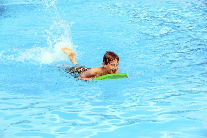 Teen Boy Swimming in a Pool with a Boogie Board Stock Photo - Image of ...