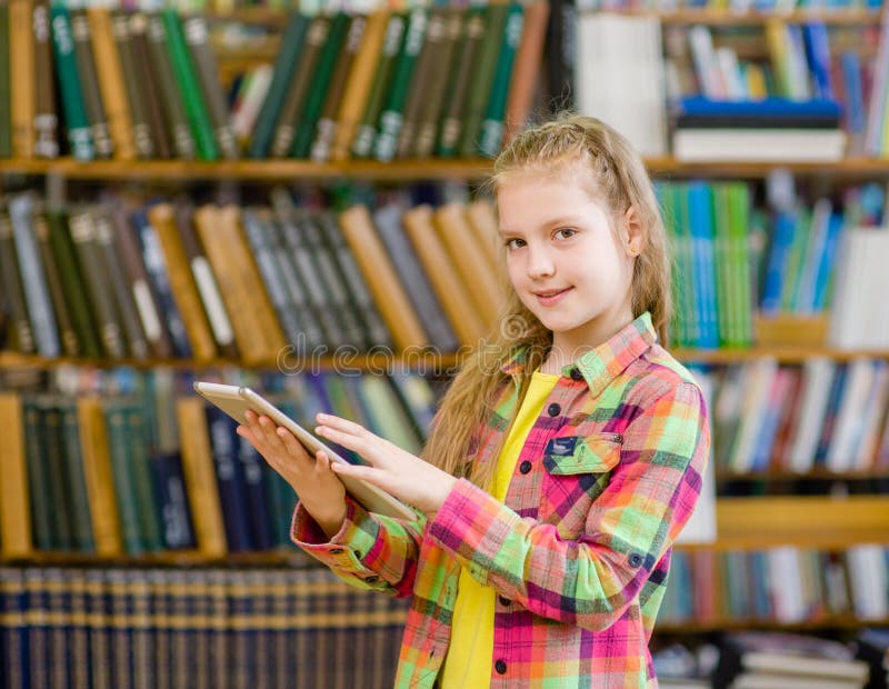 Teen Girl Using a Tablet Computer in a Library Stock Image - Image of ...