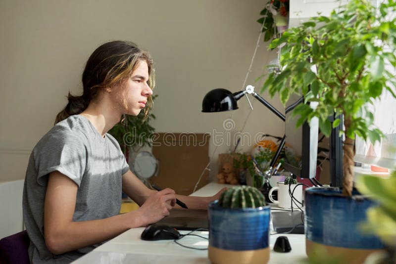Teen Guy at Home Working on Computer, Using Graphics Tablet To Work ...