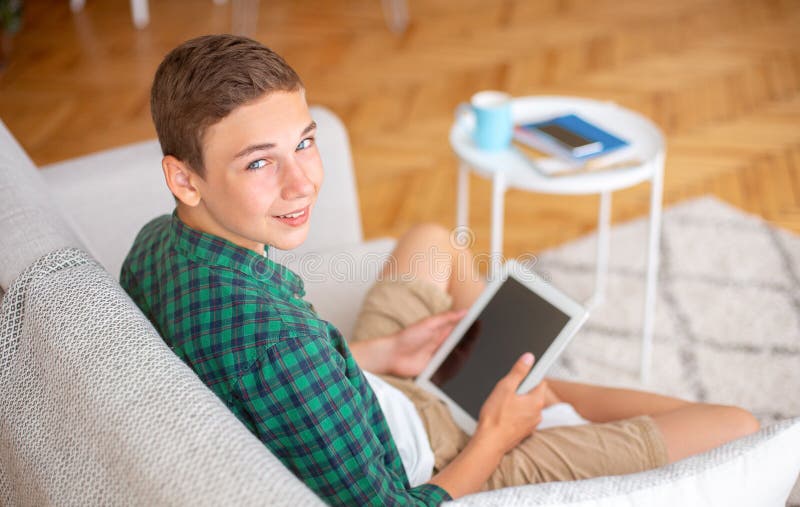 Teen Guy Using Digital Tablet with Empty Screen, Home Interior Stock ...