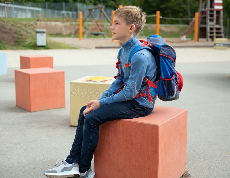 Teen Schoolboy with Backpack Sitting in the School Yard Stock Image ...